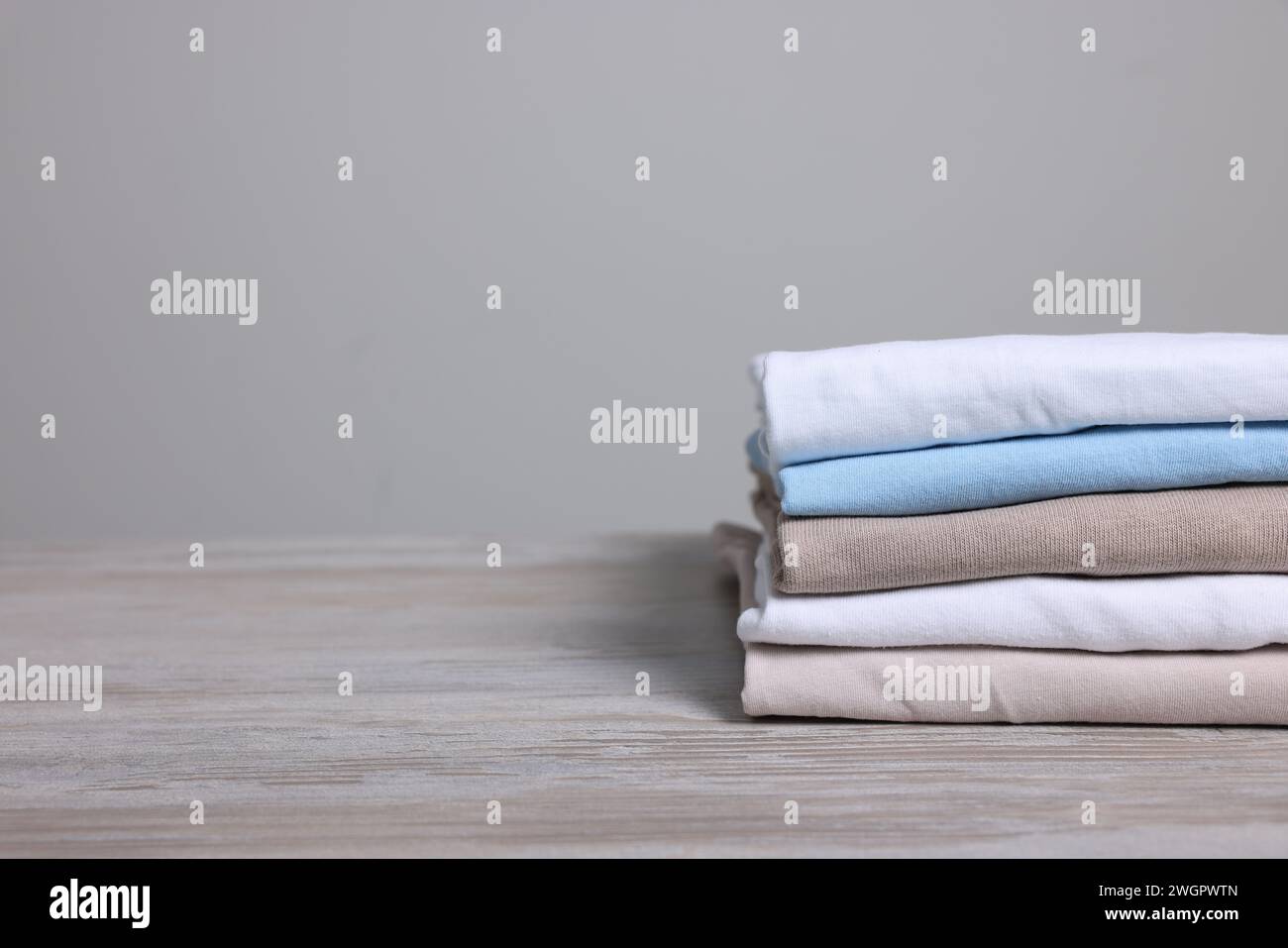 Sorting and organizing. Stack of different folded clothes on light ...
