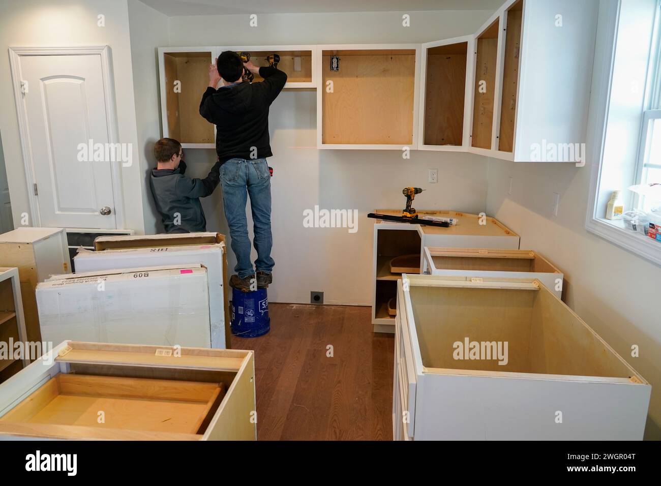 Daryl Shirk and Delmar Hoover, left, install a set of kitchen cabinets ...