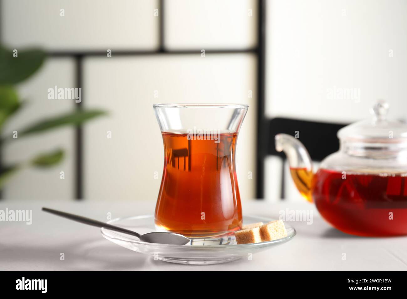 Traditional Turkish tea in glass and sugar cubes on white table Stock ...
