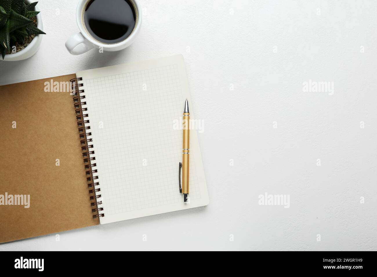 Flat lay composition with open notebook on white table. Space for text ...
