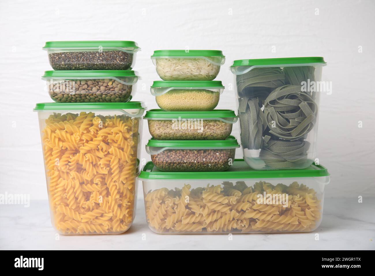 Plastic containers filled with food products on white table Stock Photo ...