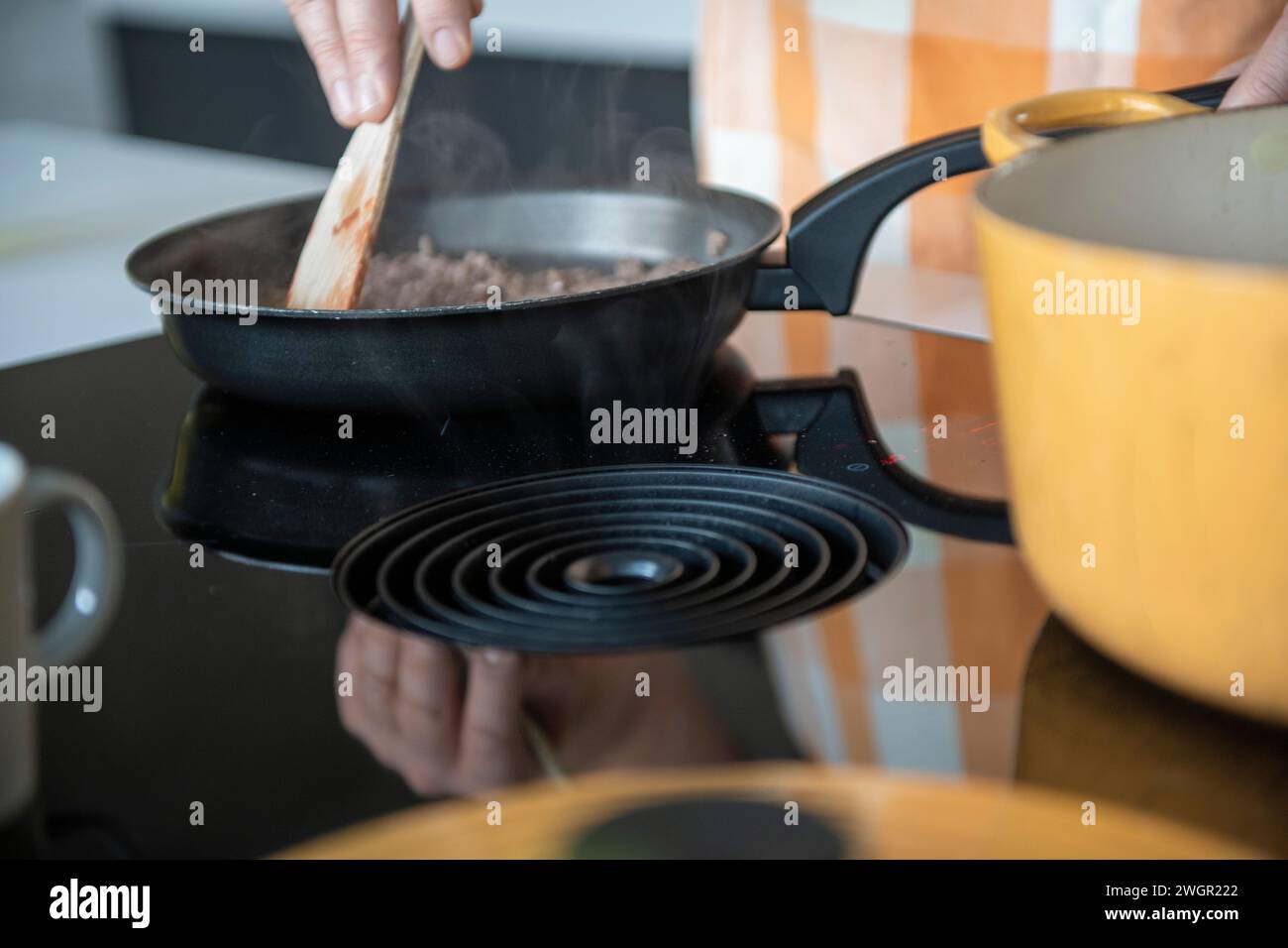 Adult man preparing mince for a lasagne in his modern kitchen Stock ...