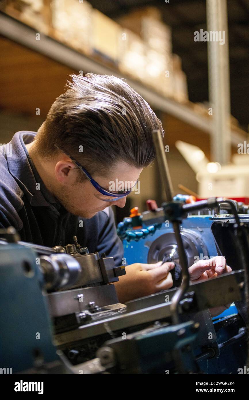 Young mechanical engineer working on steel machinery in a factory ...