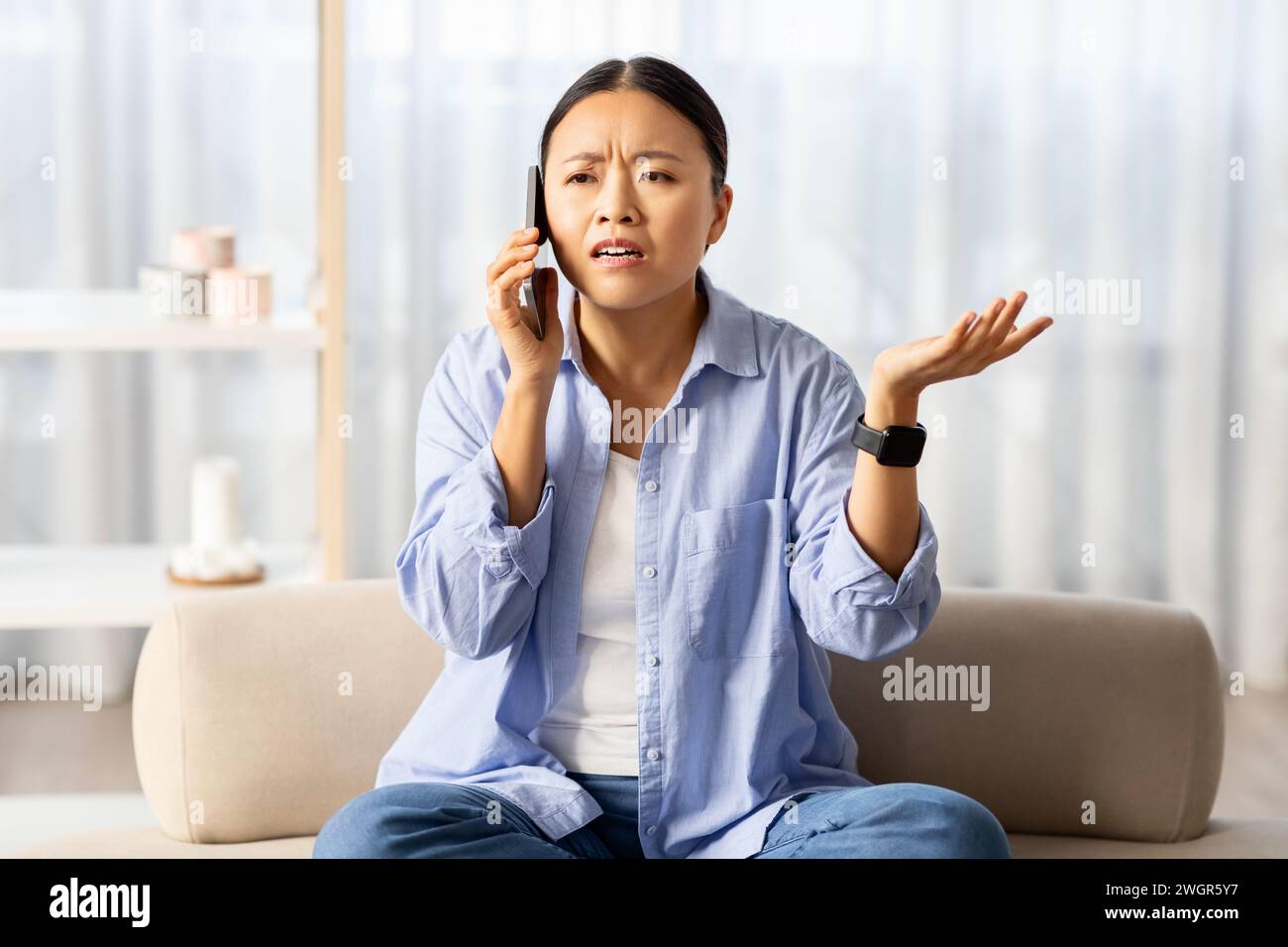Angry asian woman fighting over phone with boyfriend Stock Photo - Alamy