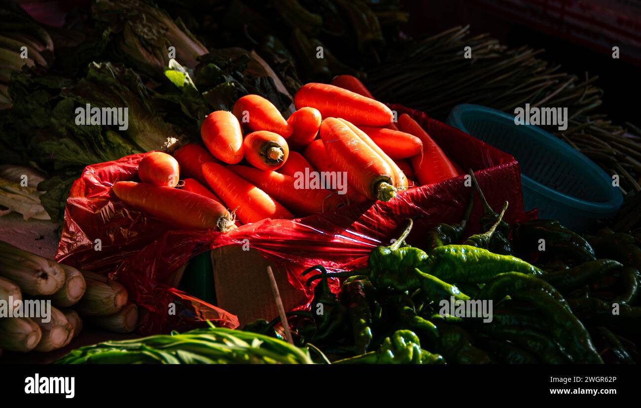 A vibrant assortment of red carrots and other fresh vegetables ...