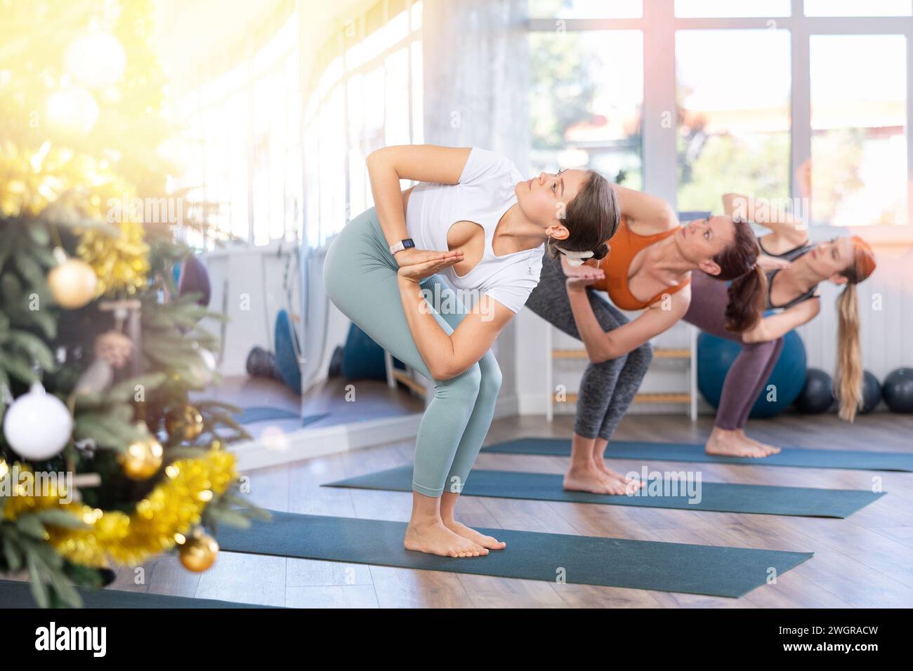 Young female yoga trainer conducting group class on Christmas eve Stock ...