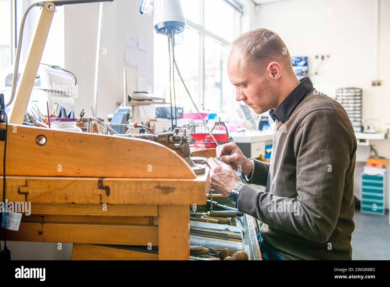 Watch maker repairing a classic watch and jewelry, authentic work place ...