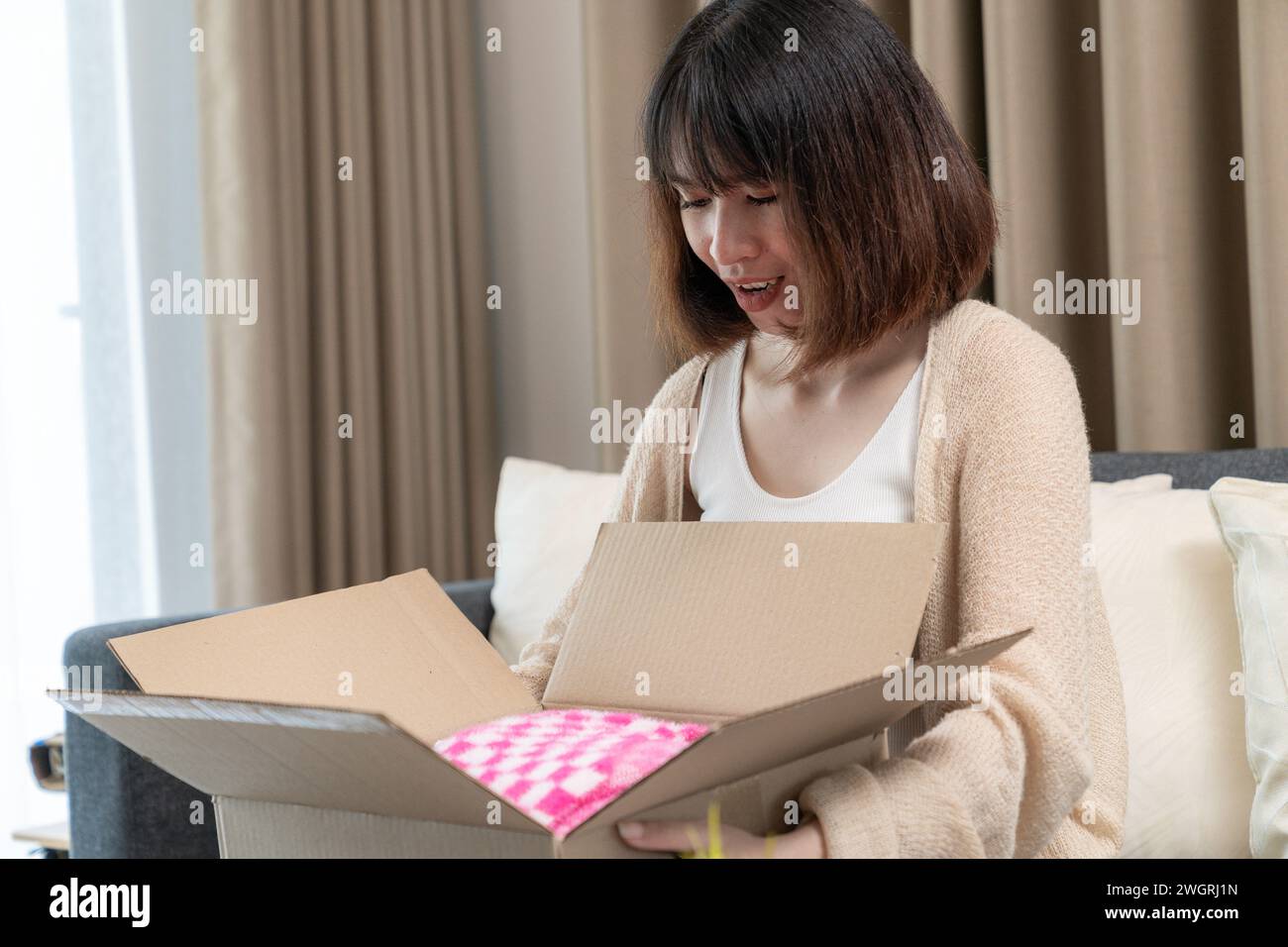 Excited young woman with items she ordered Stock Photo - Alamy