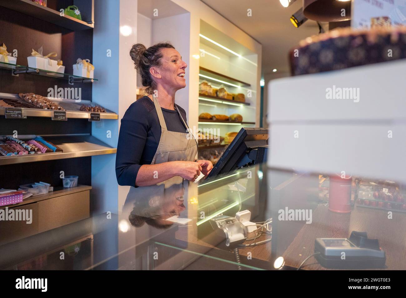 Female baker assisting a customer with their purchase Stock Photo - Alamy