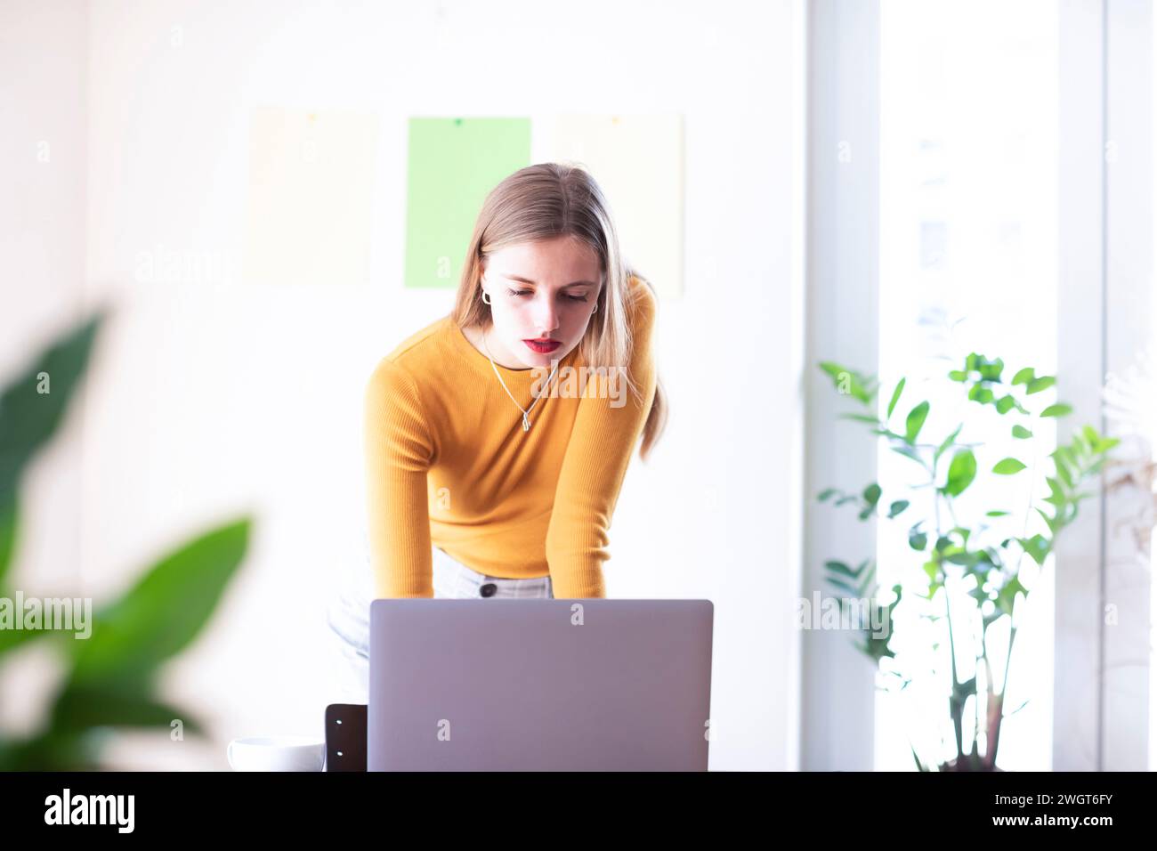 Woman sitting in yellow office hi-res stock photography and images - Alamy