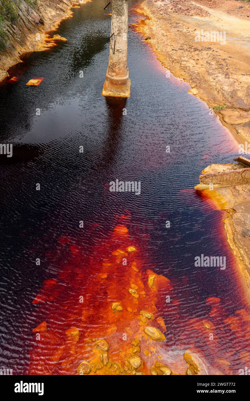 The otherworldly red waters of Rio Tinto flow beside steep rocky cliffs ...