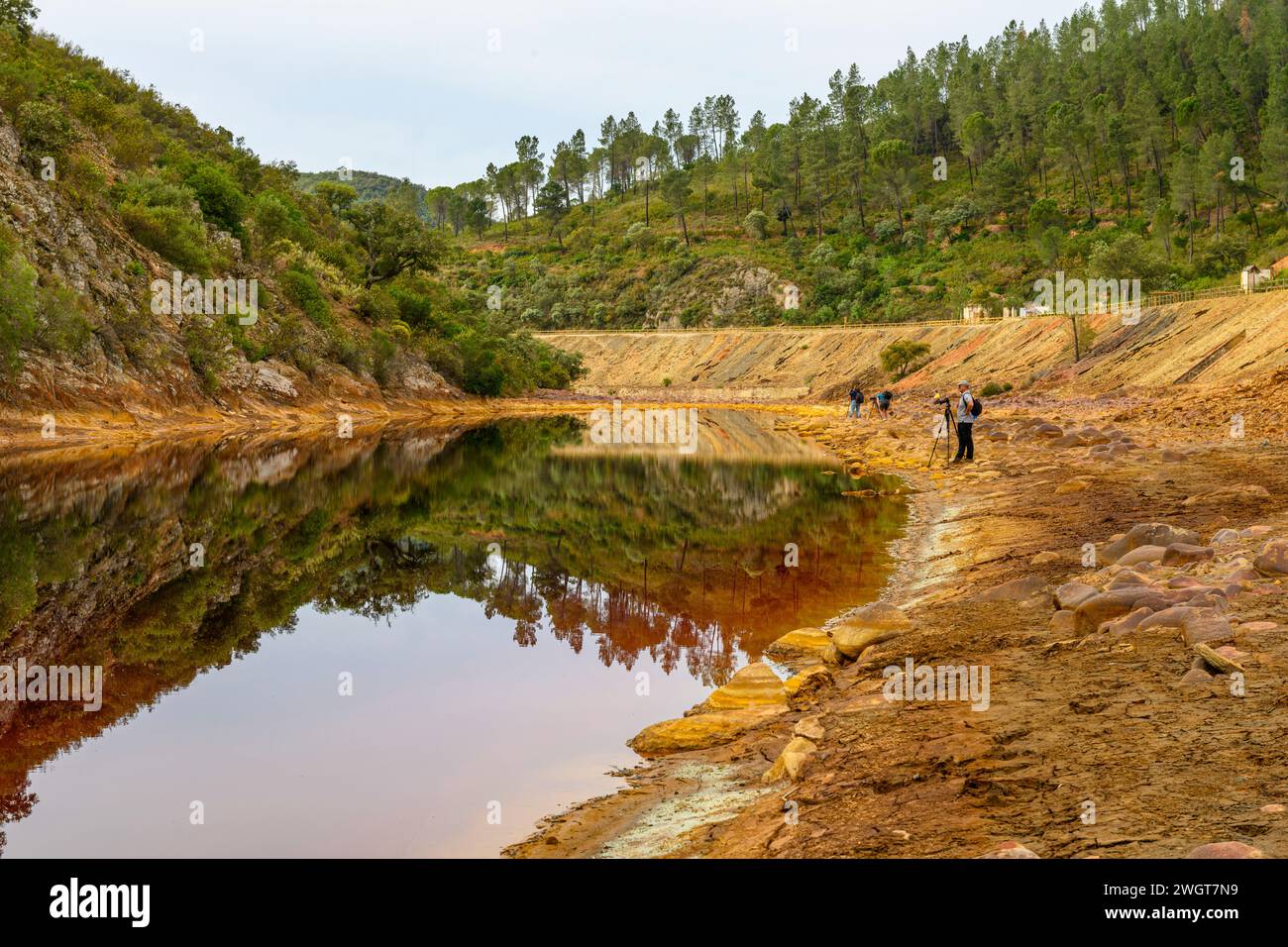 Striking layers of earth and a vivid streak of red water line the ...