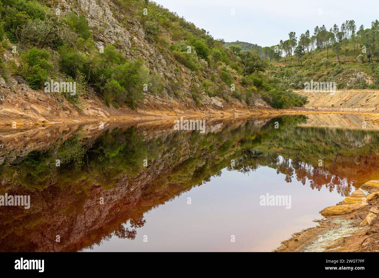 Striking layers of earth and a vivid streak of red water line the ...