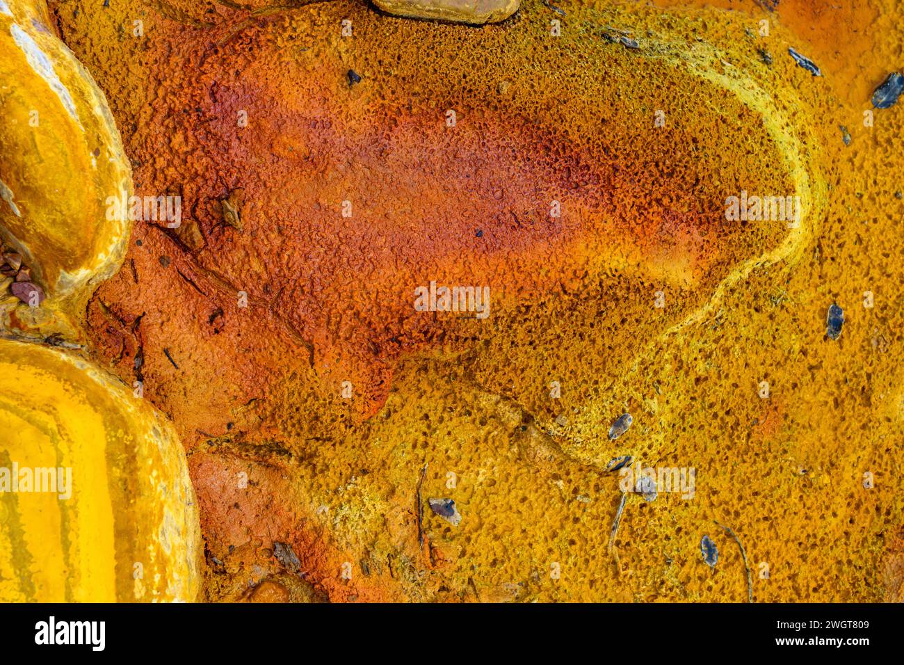 Striking layers of earth and a vivid streak of red water line the ...