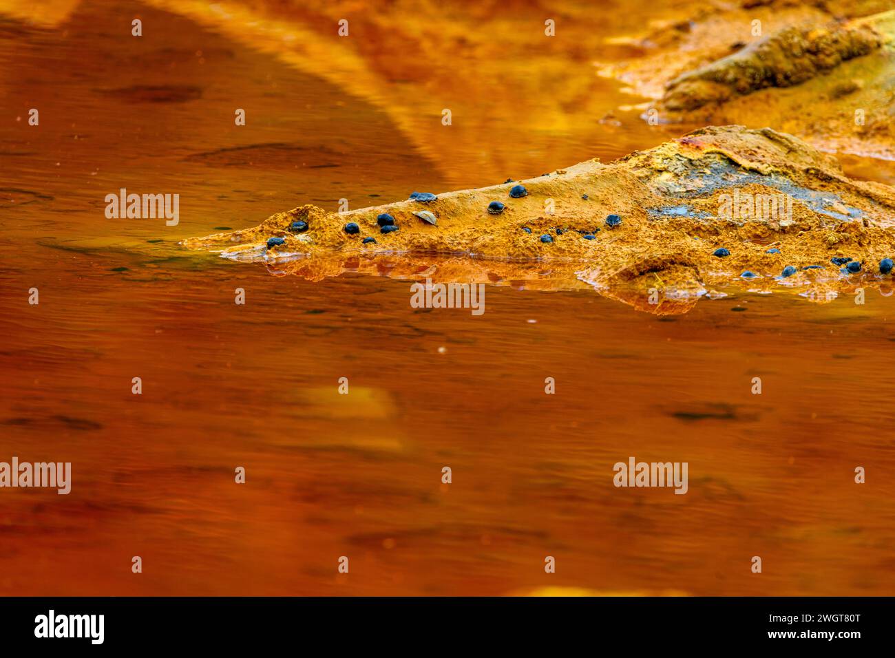 Striking layers of earth and a vivid streak of red water line the ...
