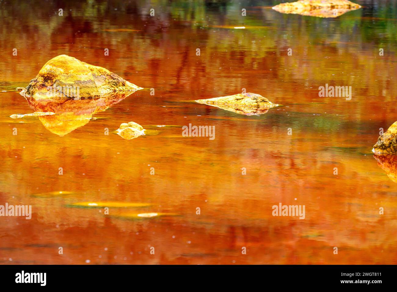 Striking layers of earth and a vivid streak of red water line the ...