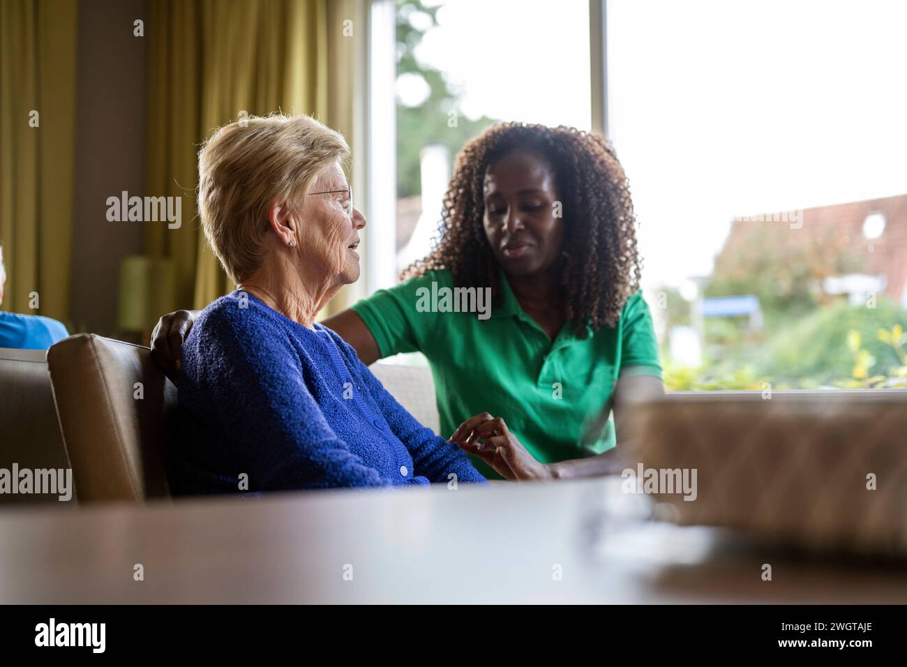 Helper caring for elderly lady Stock Photo - Alamy