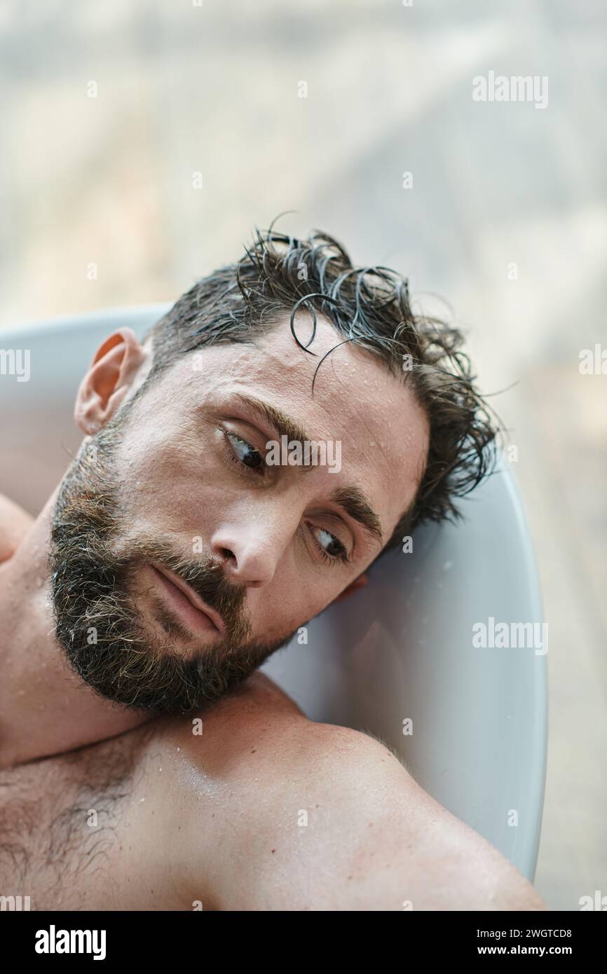 traumatized frustrated man with beard lying in bathtub during breakdown ...
