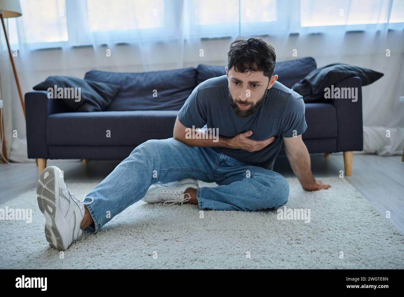 bearded suffering man in casual home wear having severe panic attack ...