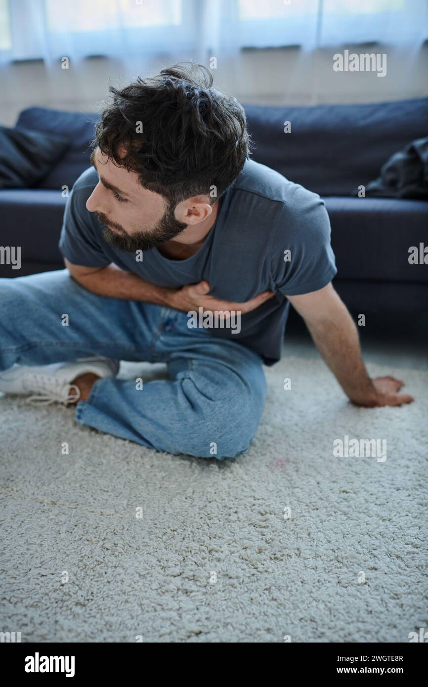 bearded suffering man in casual home wear having severe panic attack ...