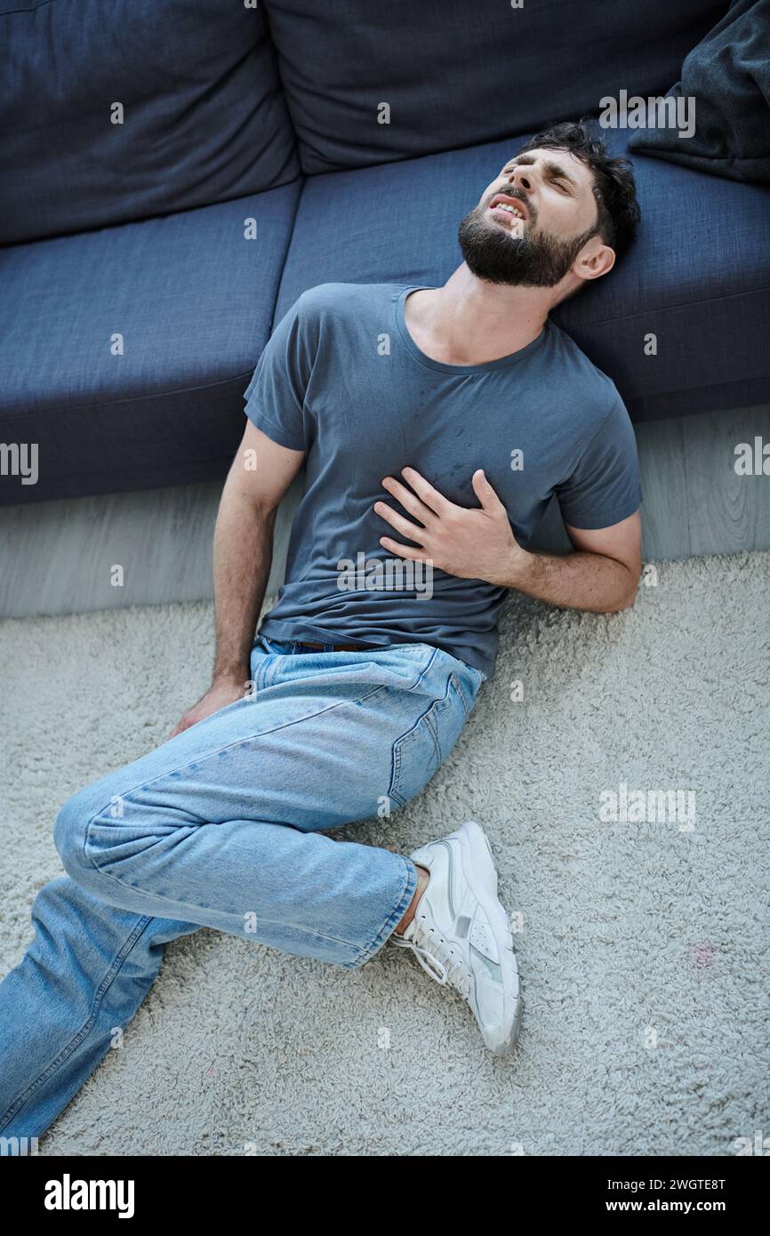 anxious traumatized man in casual home wear having severe panic attack ...