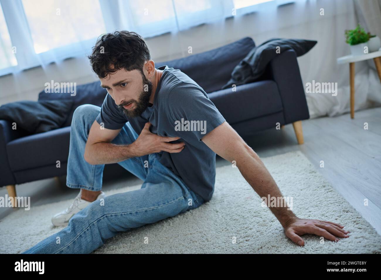 depressed traumatized man with beard in homewear having severe panic ...