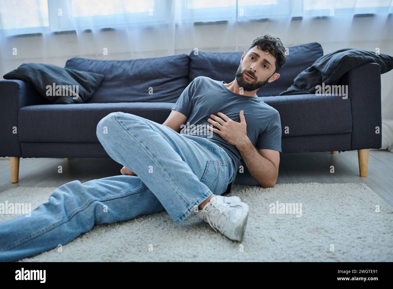 anxious traumatized man in casual home wear having severe panic attack ...