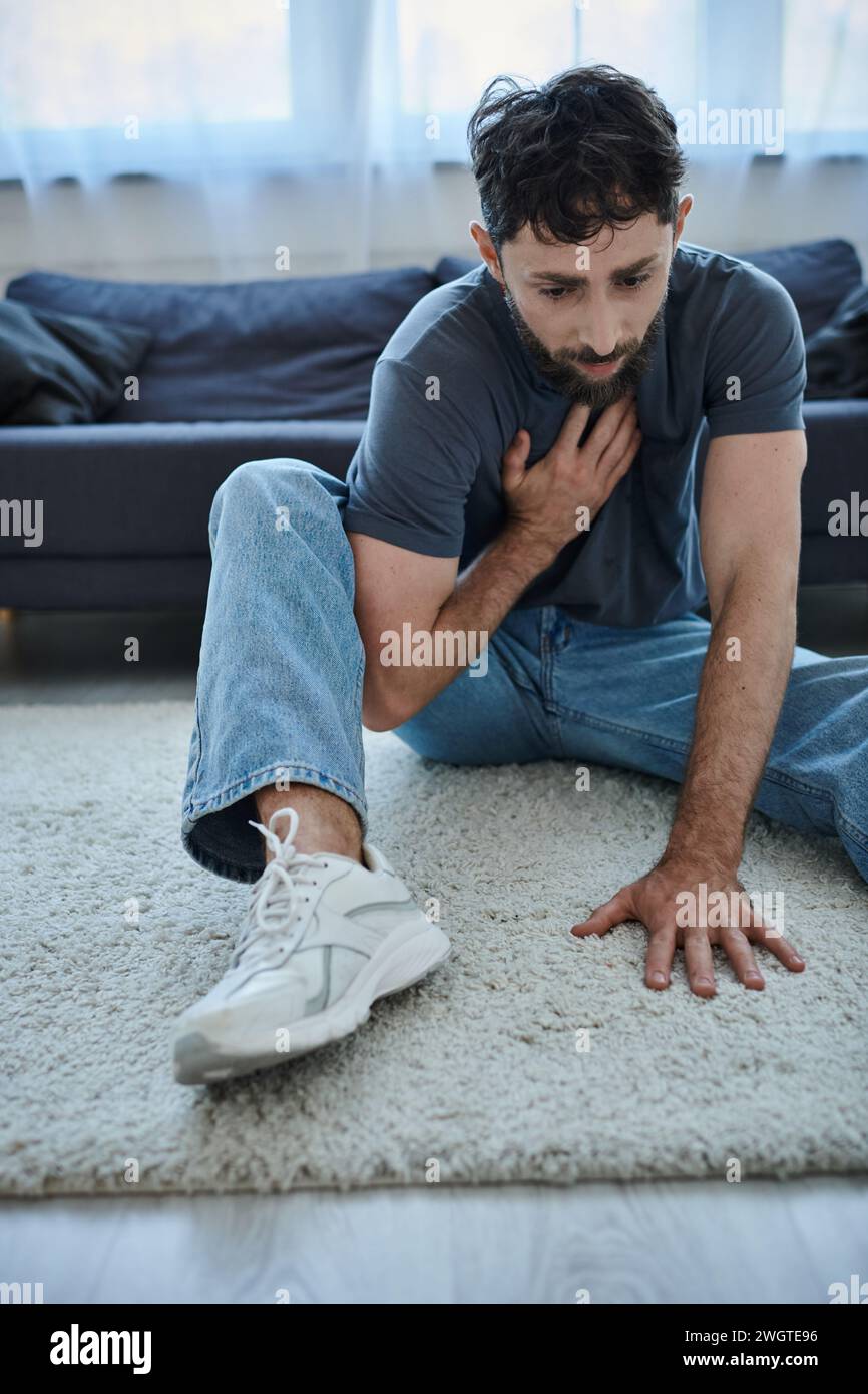 depressed traumatized man with beard in home wear having panic attack ...