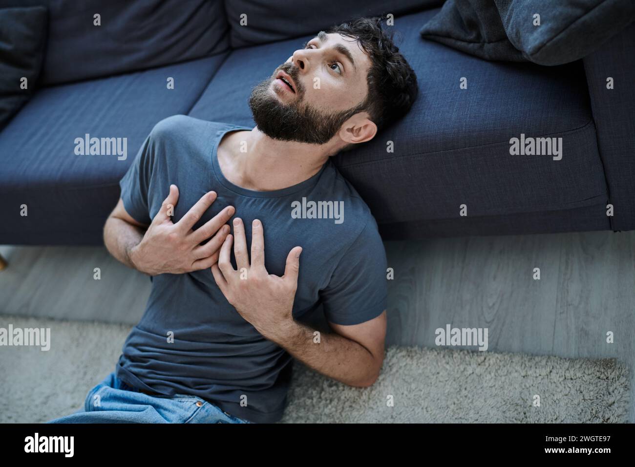 ill traumatized man with beard in home wear having severe panic attack ...