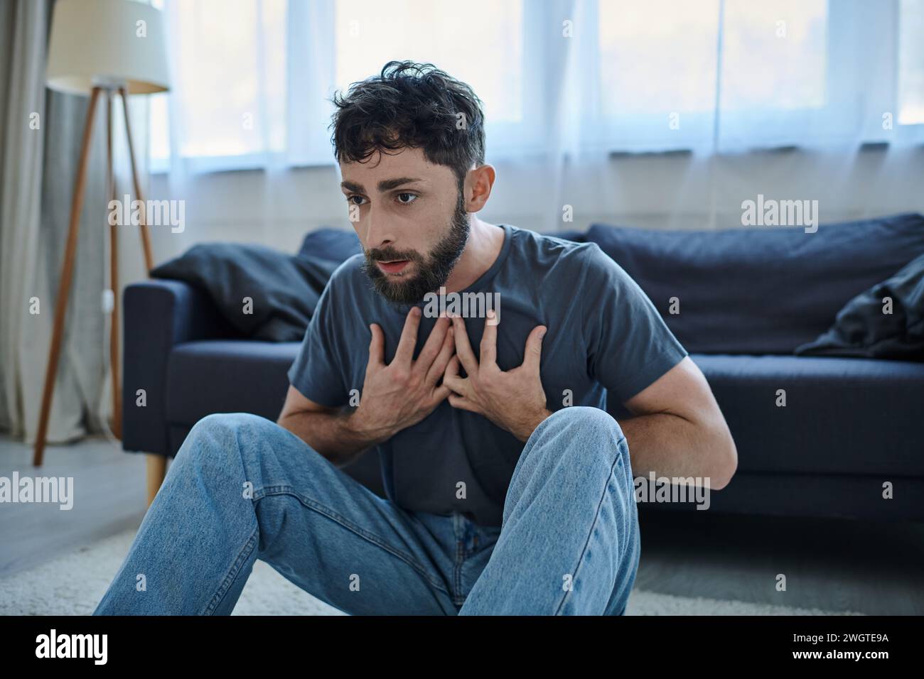 ill traumatized man with beard in homewear having severe panic attack ...