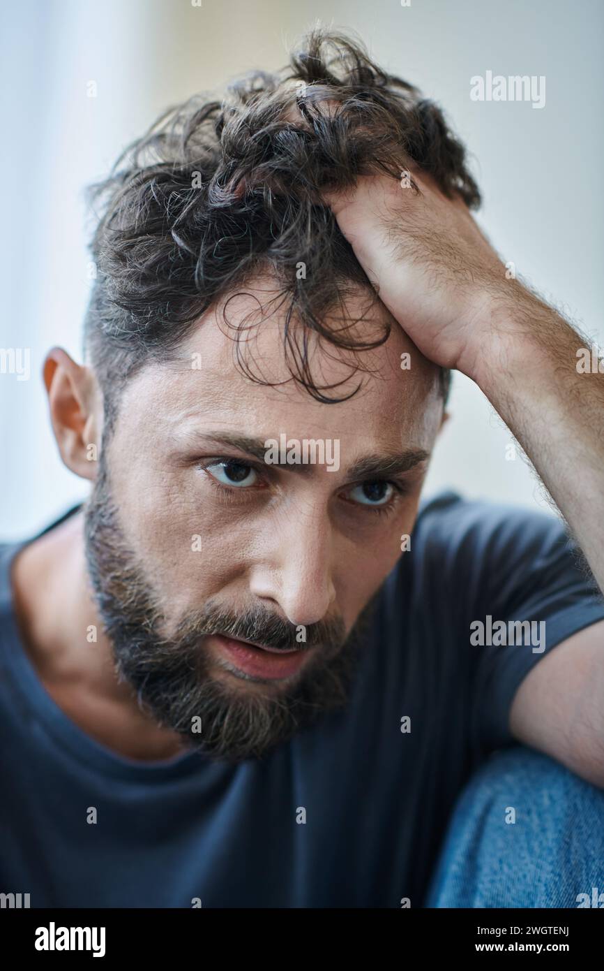 sick depressed man with beard with hand on his face during breakdown ...