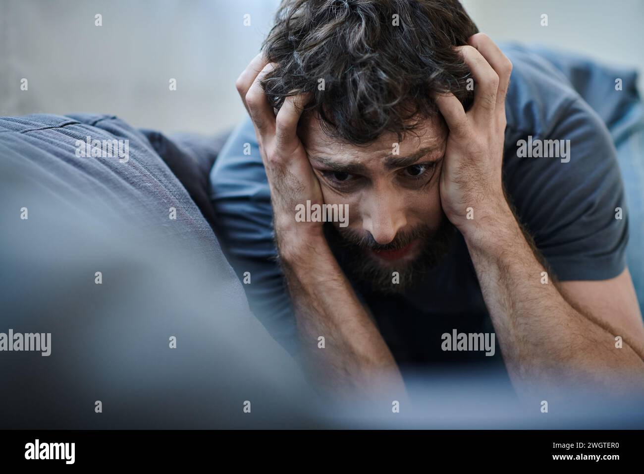 desperate man with beard screaming with hand on his face during ...