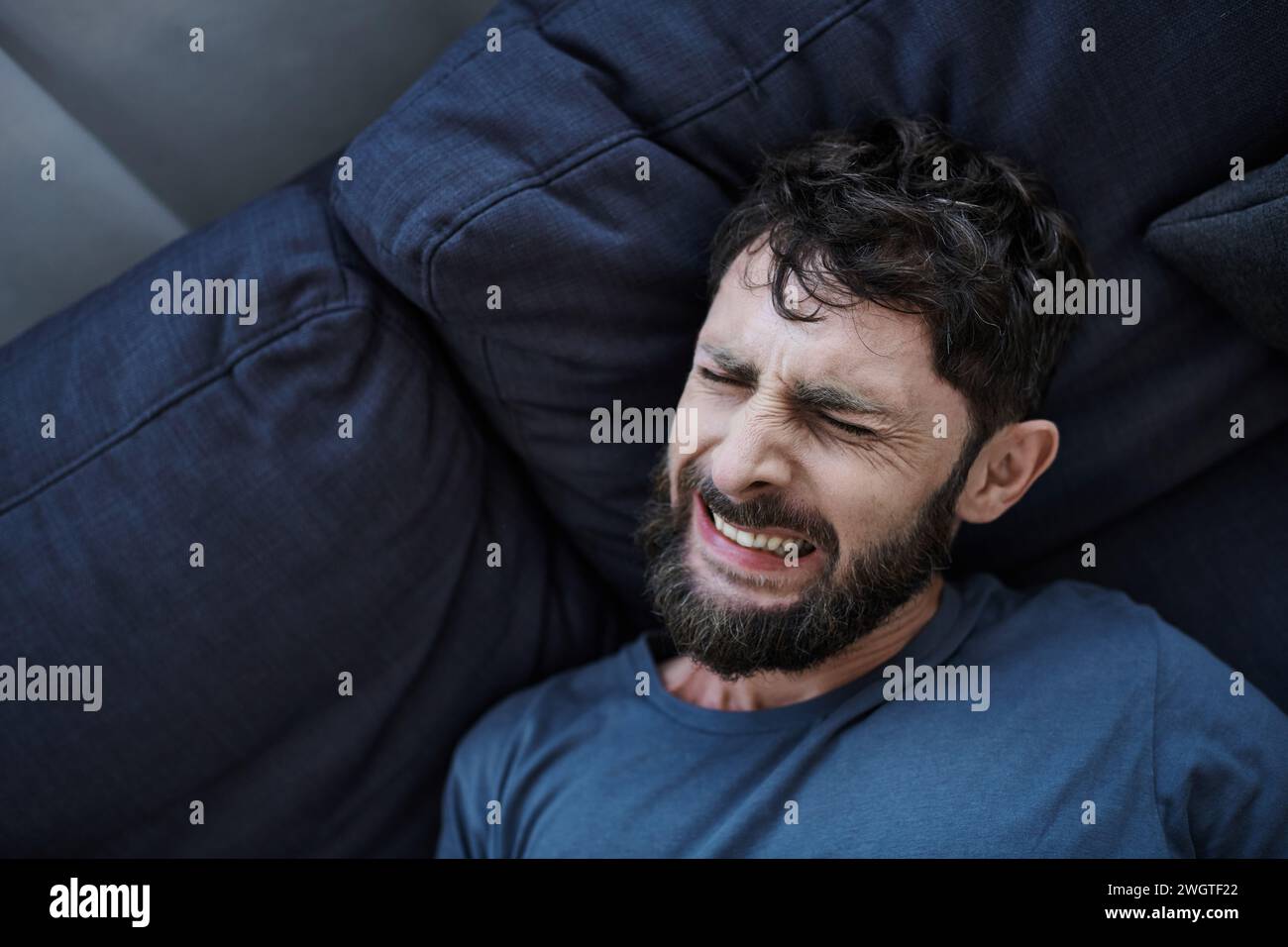anxious man with beard in casual clothes suffering during breakdown ...