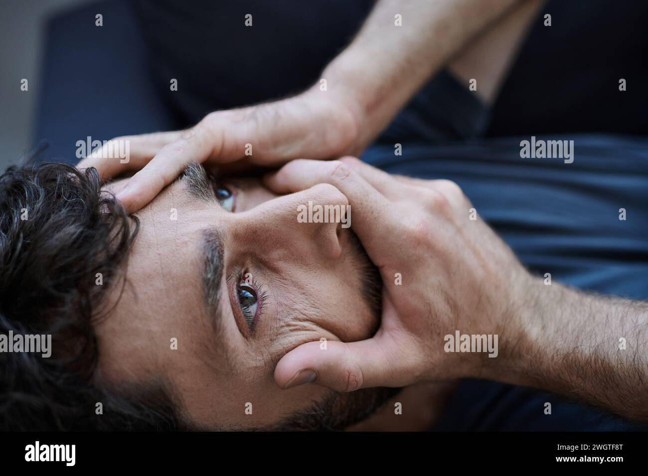 stressed desperate man with beard in casual attire lying with hands on ...