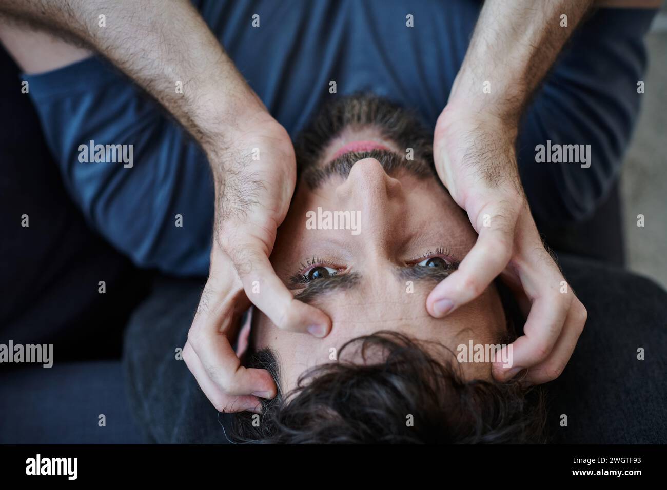 stressed desperate man with beard in casual attire lying with hands on ...