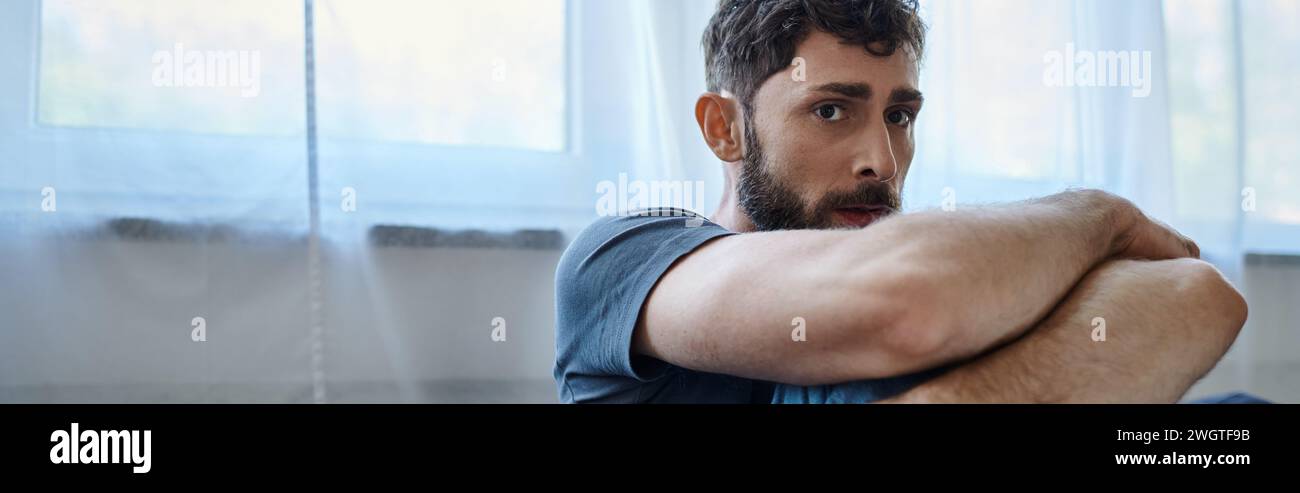 bearded anxious man sitting on sofa during mental break down and ...