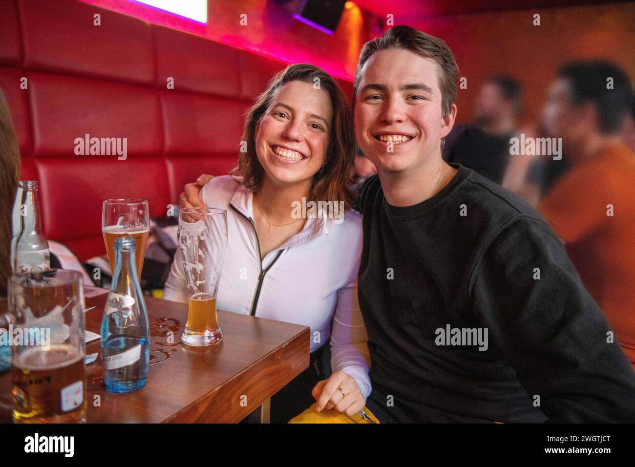 young friends celebrating in a bar having fun laughing and messing ...