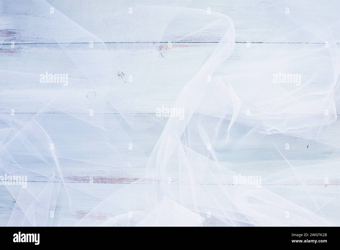 White Tulle over a teal blue background. Table top view with free space ...