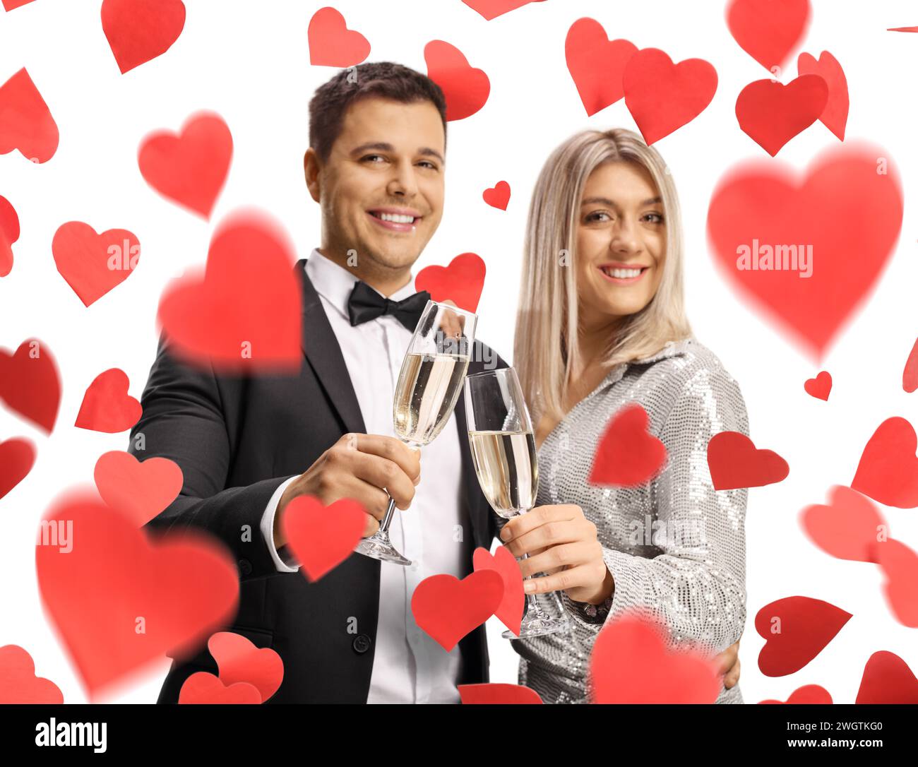 Hearts falling on a man and woman in love with glasses of champagne ...