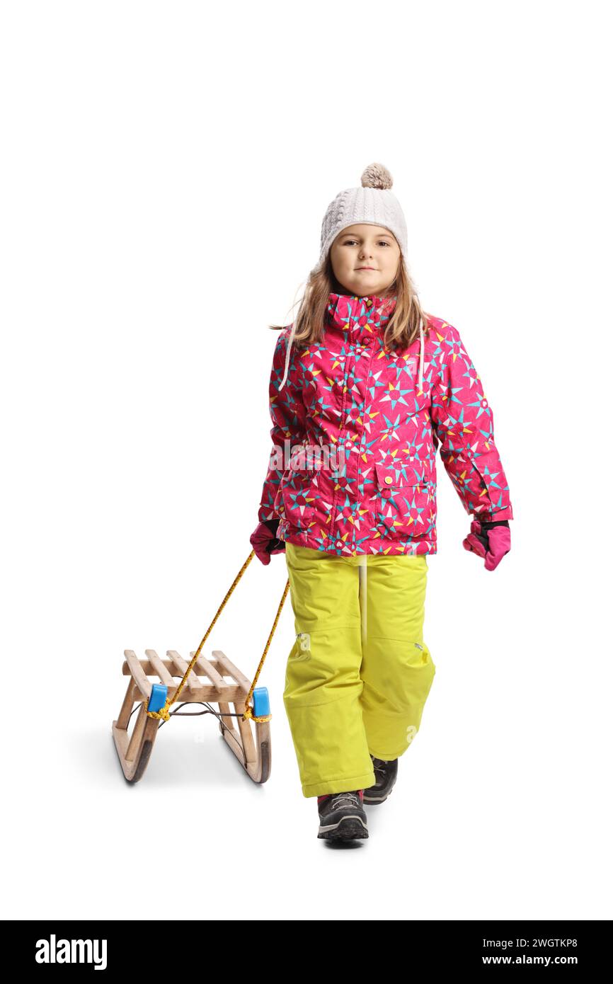 Little girl in a winter clothes pulling a wooden sled isolated on white ...