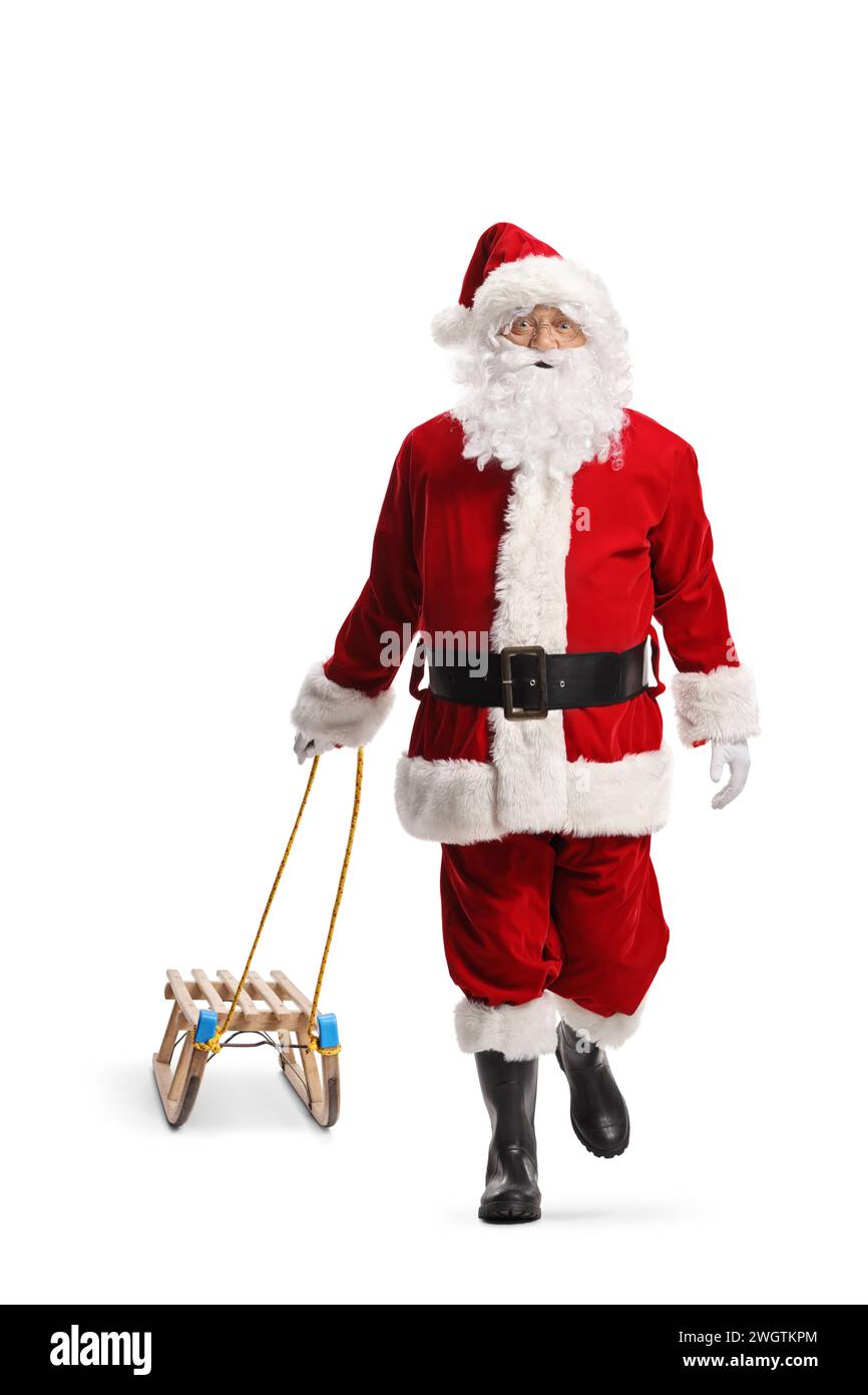 Santa Claus walking towards camera and pulling a wooden sled isolated ...