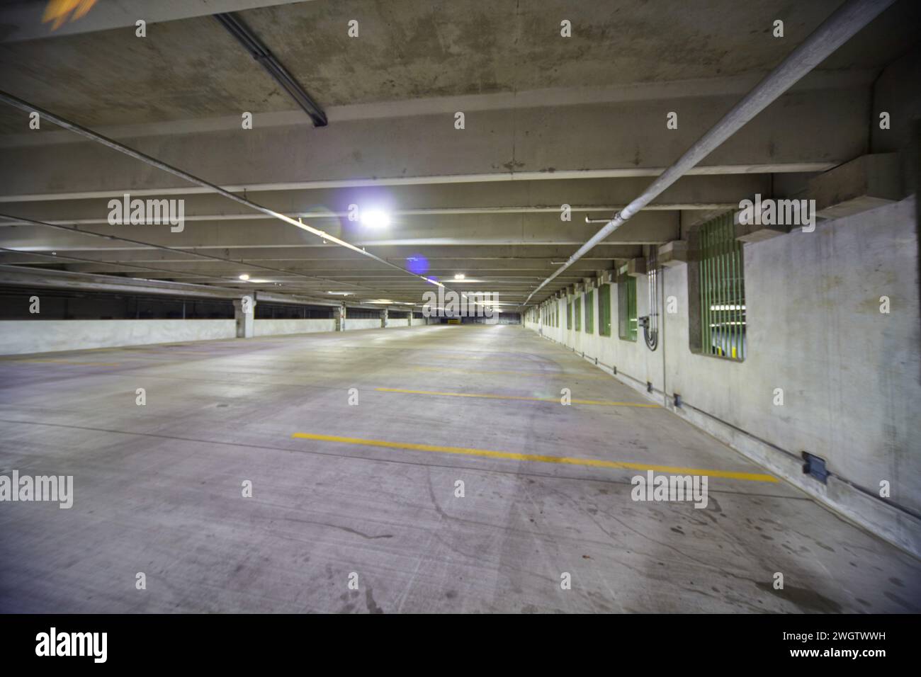 Spacious Empty Parking Garage with Fluorescent Lighting and Green ...