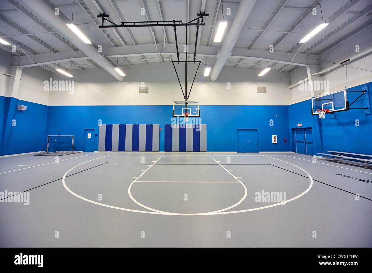 Modern Indoor Basketball Court with Blue Accents and Bright Lighting ...
