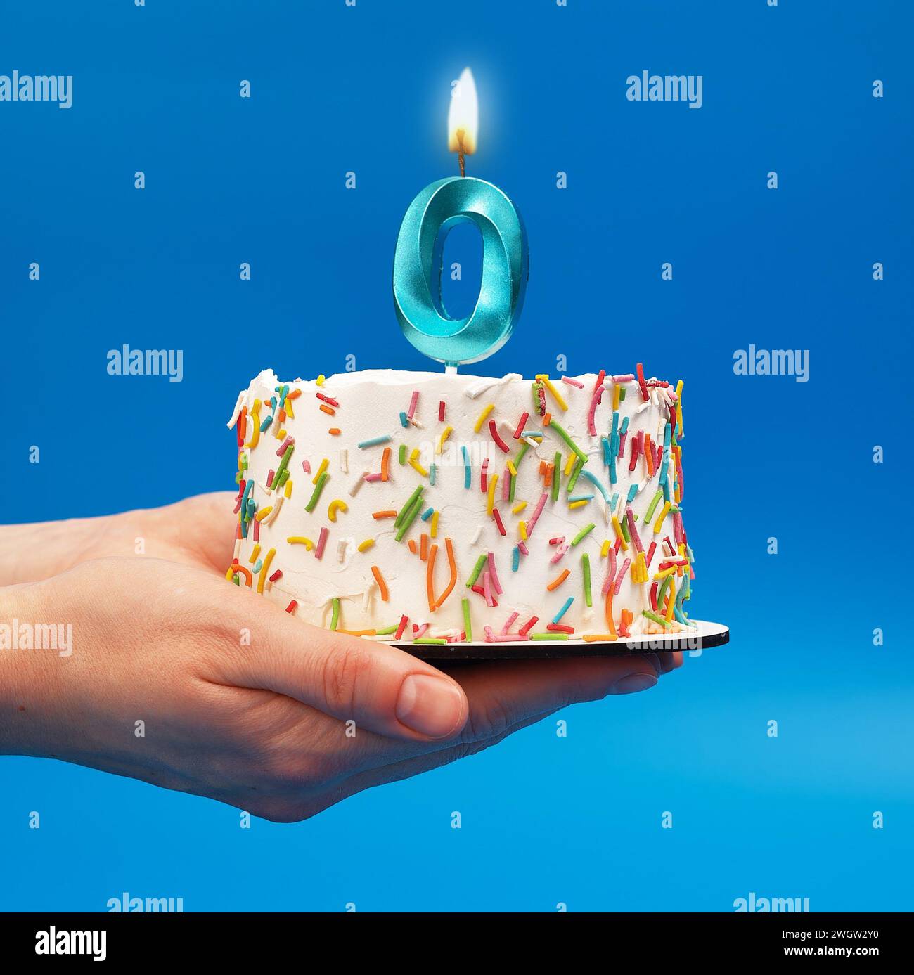 Birthday bento cake. Zero, 0 birth wax candle in hand Stock Photo - Alamy