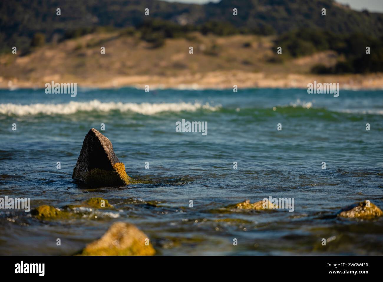The Black Sea coast. Rocks over water on a beach. Sunset light over the ...