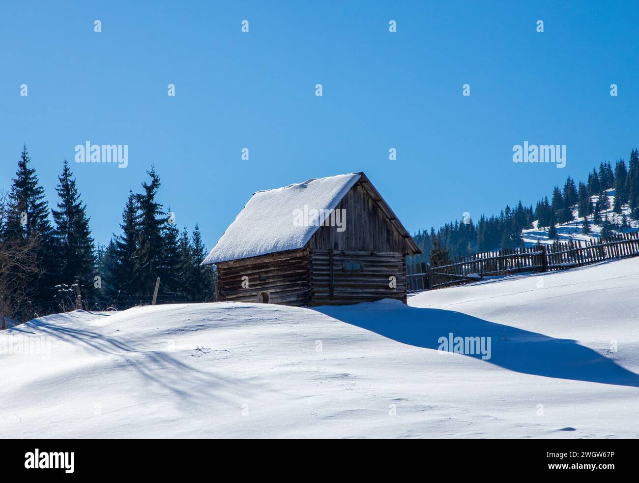 A landscape with an old wooden hut covered with snow in the mountain ...