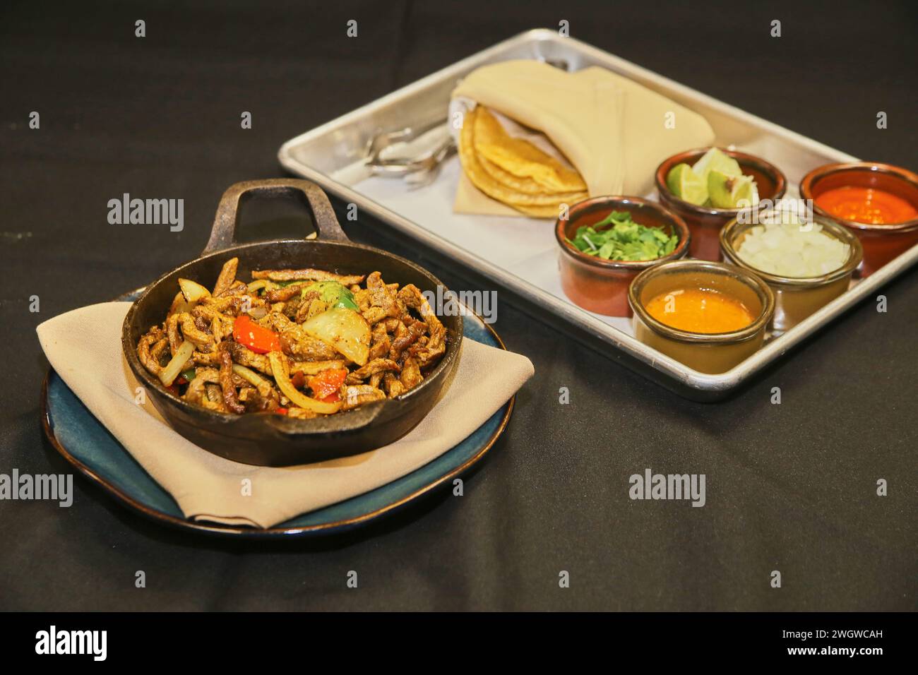 Steaming Beef Fajitas in Skillet with Condiments Side View Stock Photo ...