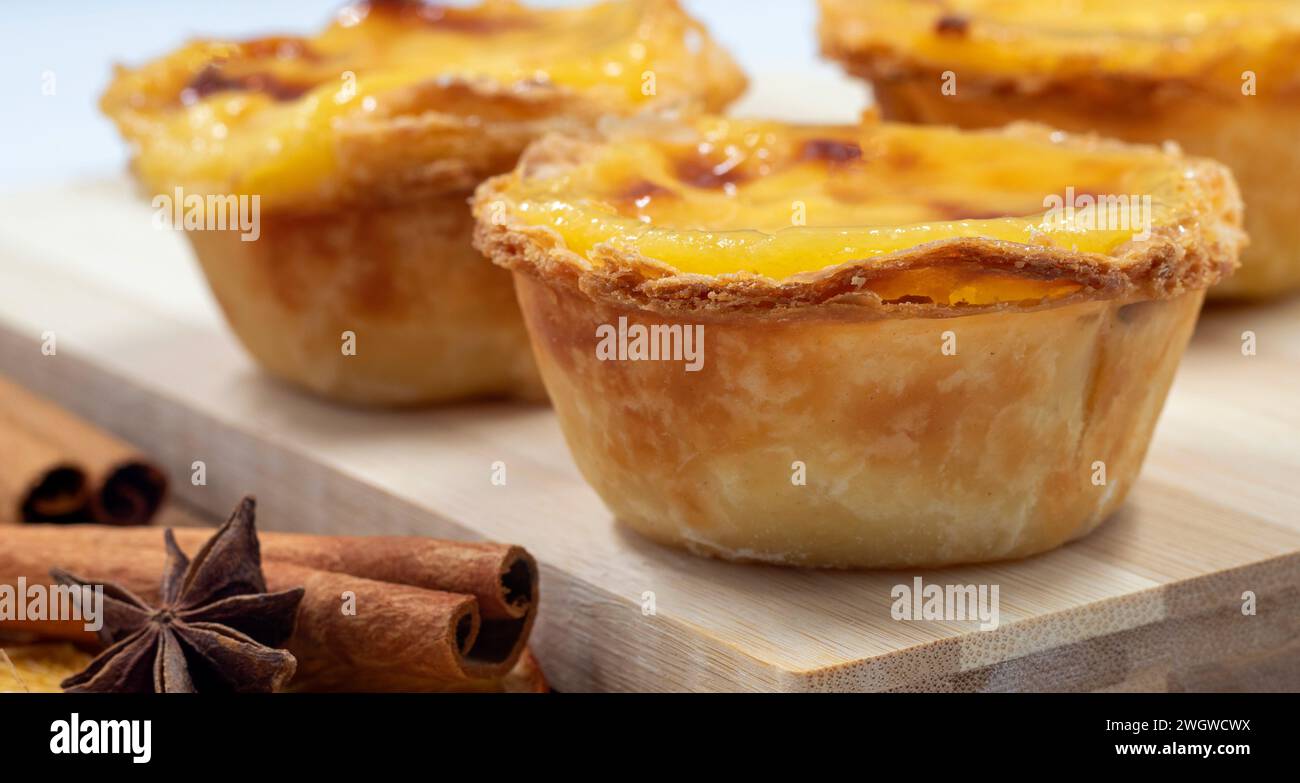 Pastel de nata tarts or Portuguese egg tart and cinnamon sticks on a ...