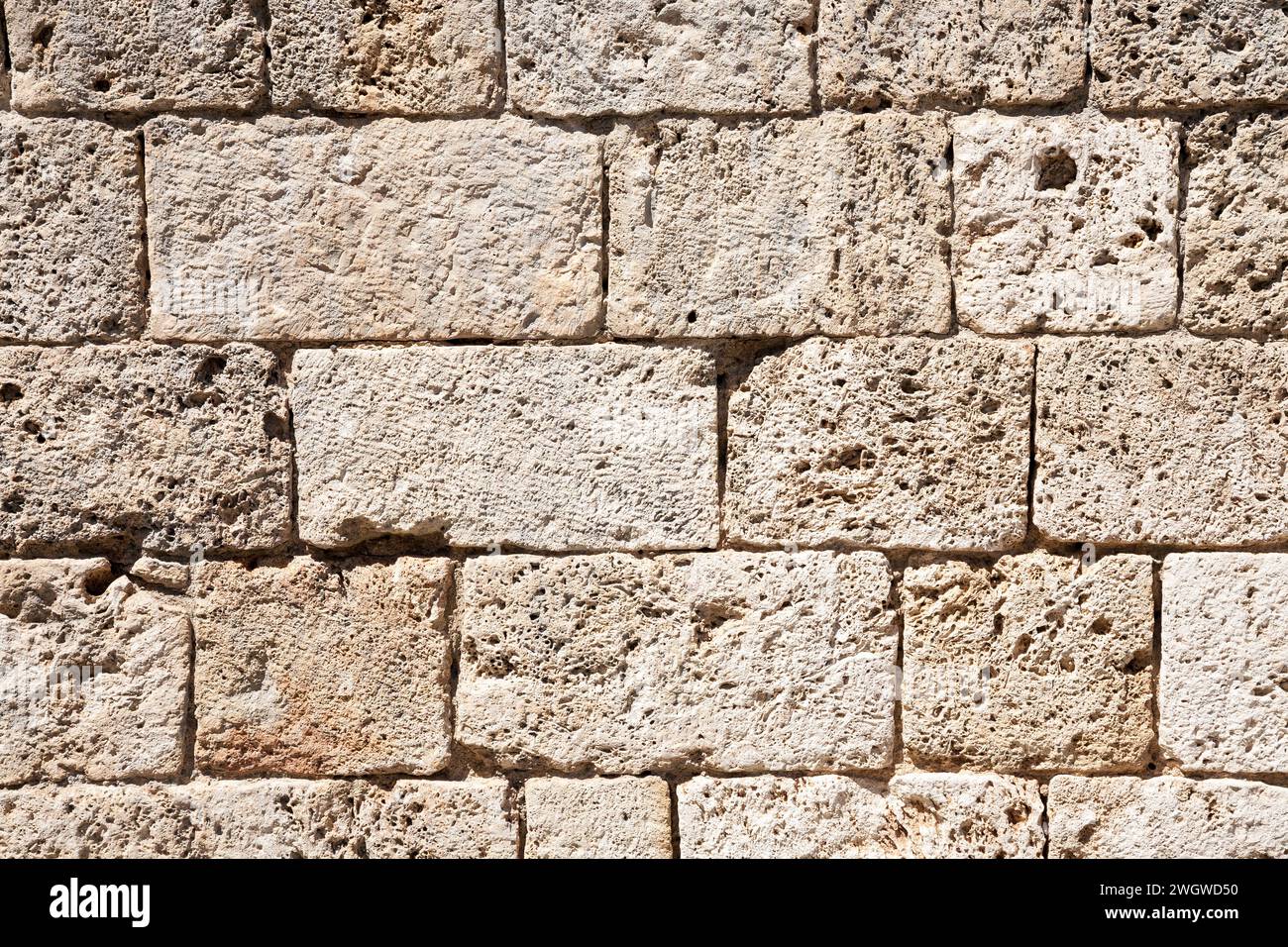 A background with an italian wall made of old textured tuff blocks ...