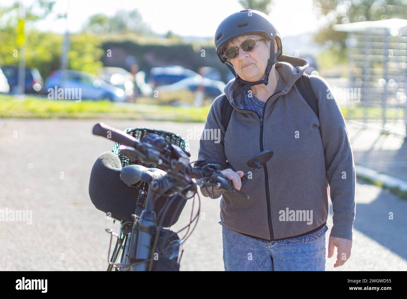 Elderly woman pushing bicycle hi-res stock photography and images - Alamy